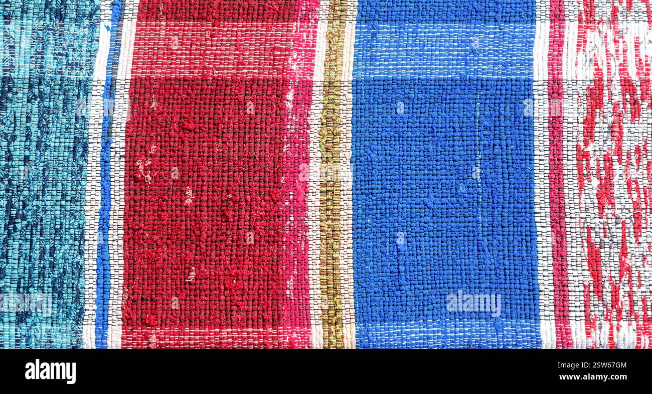 Old homespun doormat made from strips of cloth as background. Handmade ...