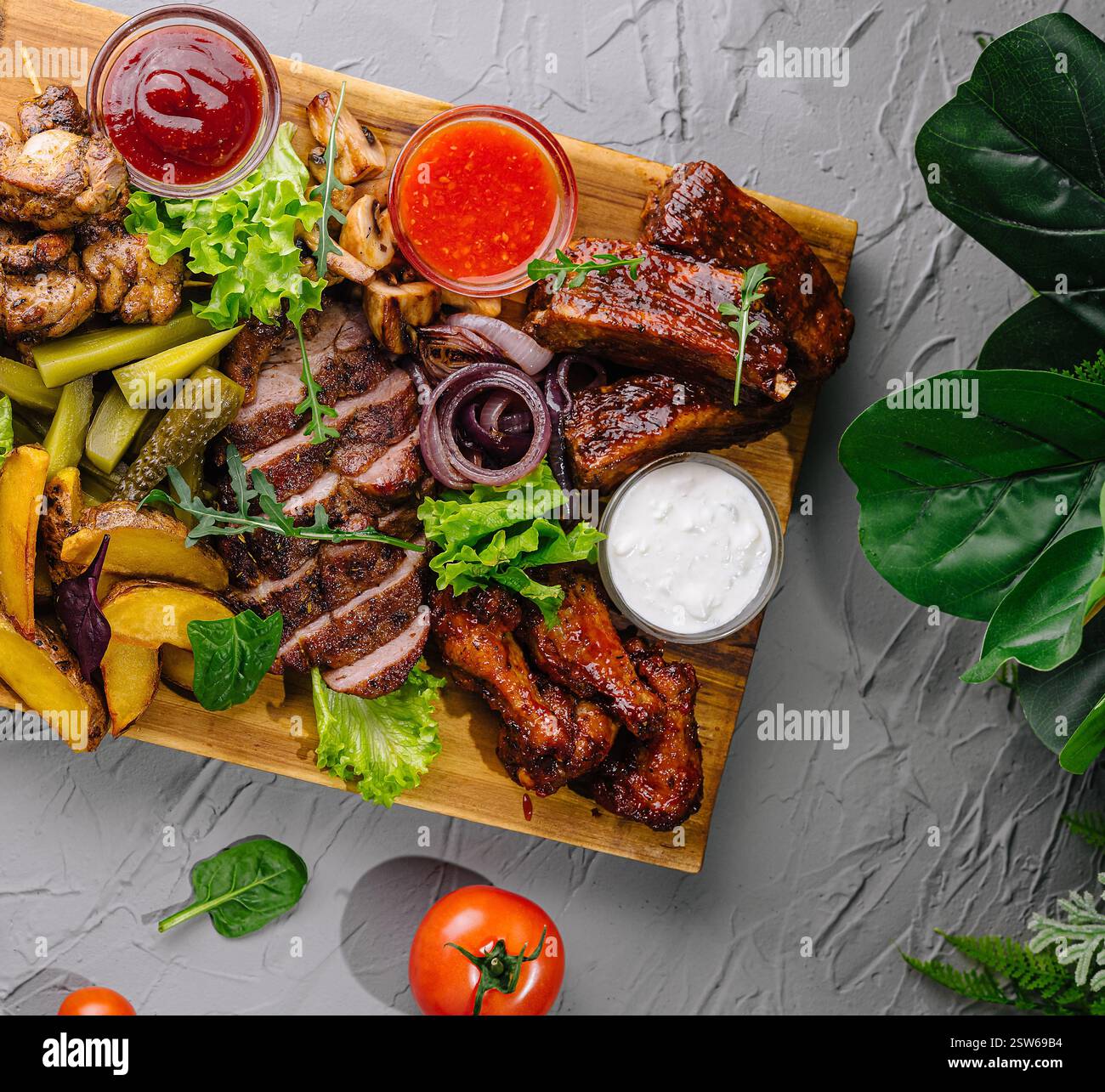 Top view of a delicious bbq feast with dips on a wooden board ...