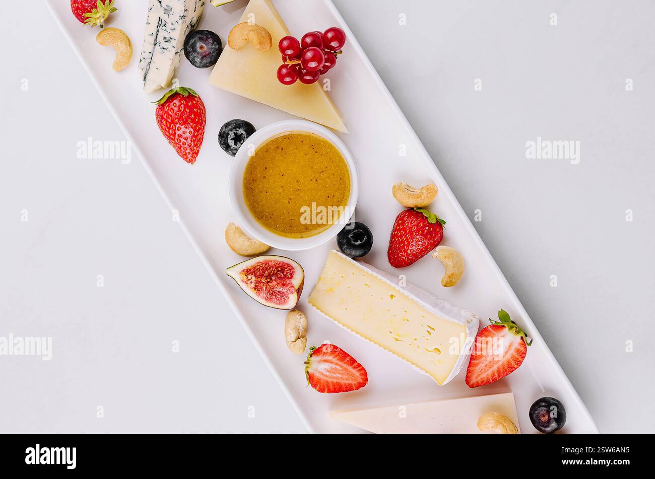 Elegant white platter featuring an assortment of fine cheeses hi-res ...