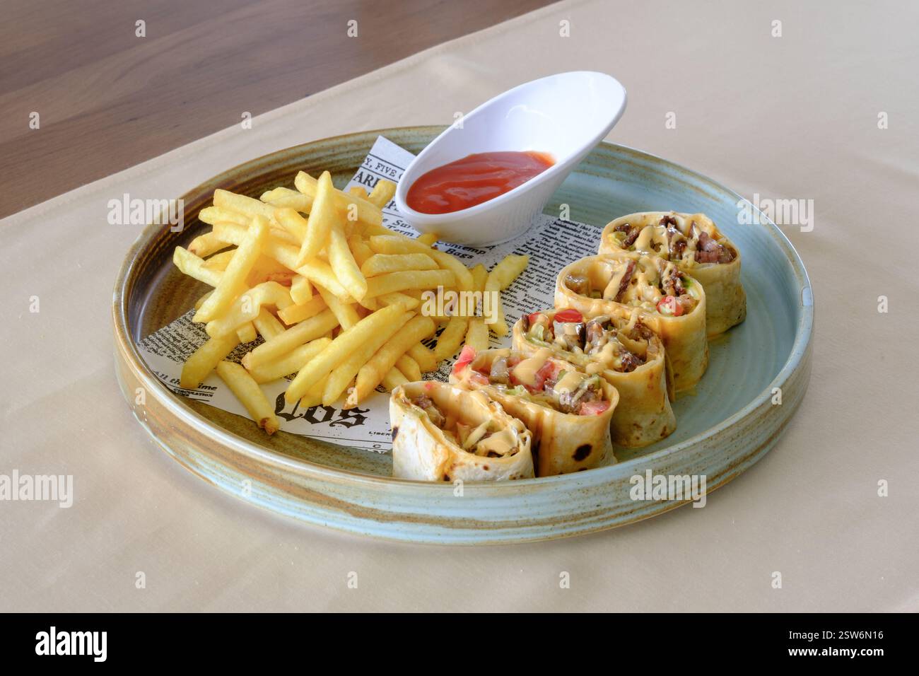 Savory meat wraps served with golden fries and a side of dipping sauce ...