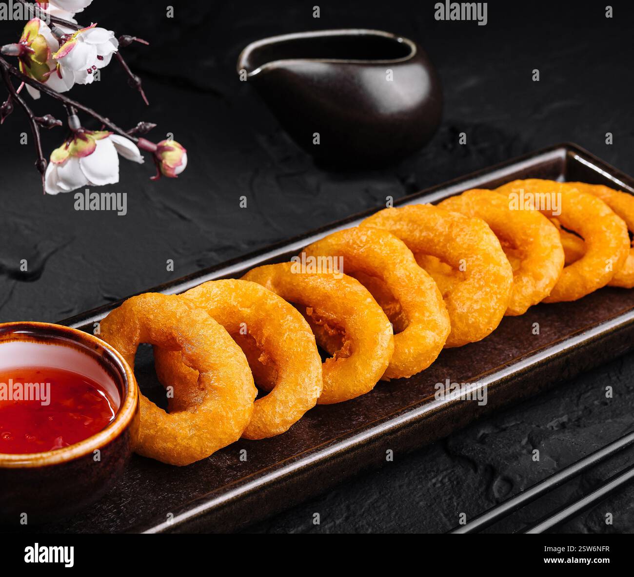 Crispy fried onion rings with dipping sauce on dark background Stock ...