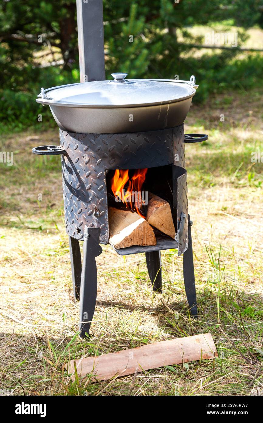 Cooking outdoors over a fire in a large metal pot Stock Photo - Alamy