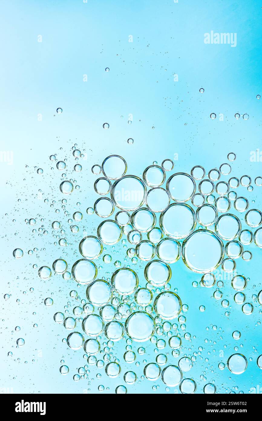 Transparent water bubbles rising in a light blue liquid background ...