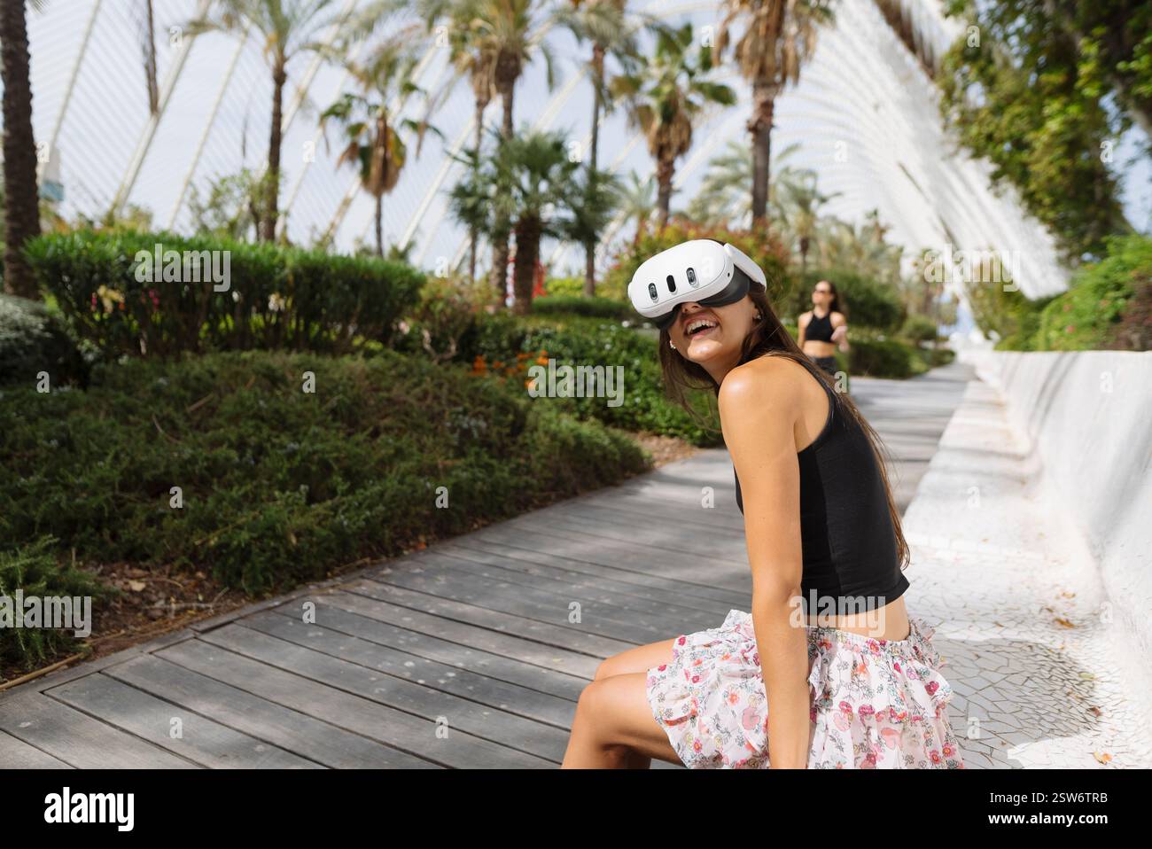 A young woman enjoying an outdoor adventure with a VR headset to ...