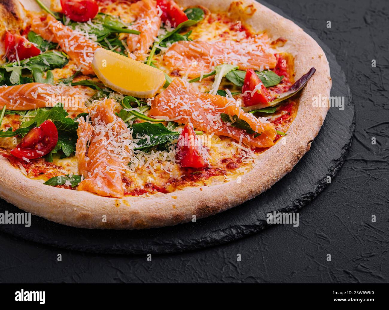 Gourmet smoked salmon pizza on dark background Stock Photo - Alamy
