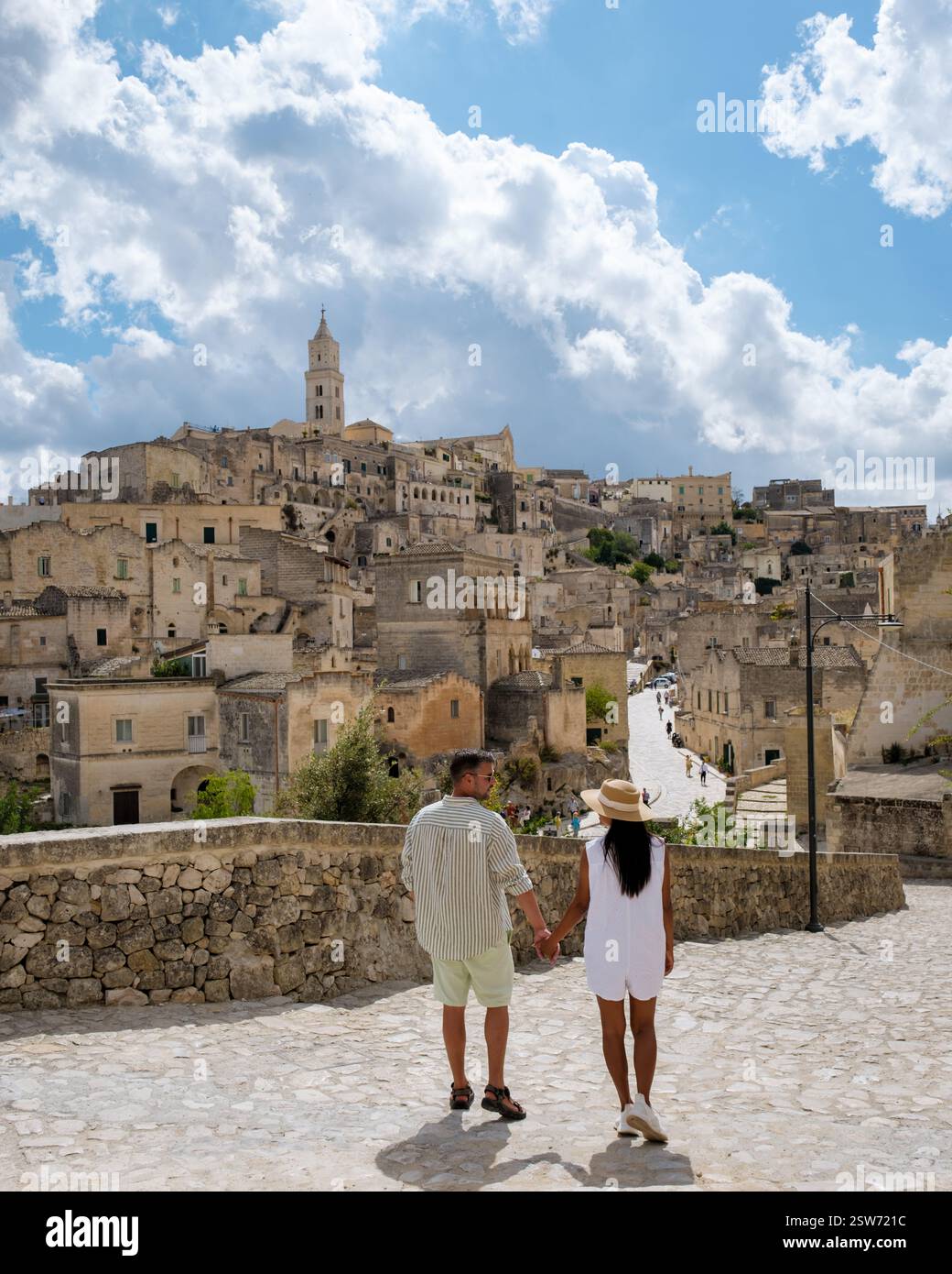 A couple strolls hand in hand through the historic stone streets of ...