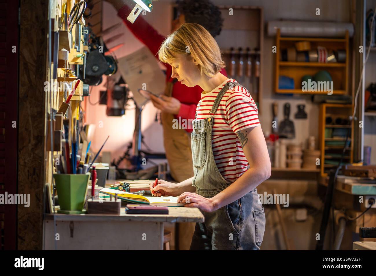 Concentrated female artisan draw sketch for furniture blueprint in ...