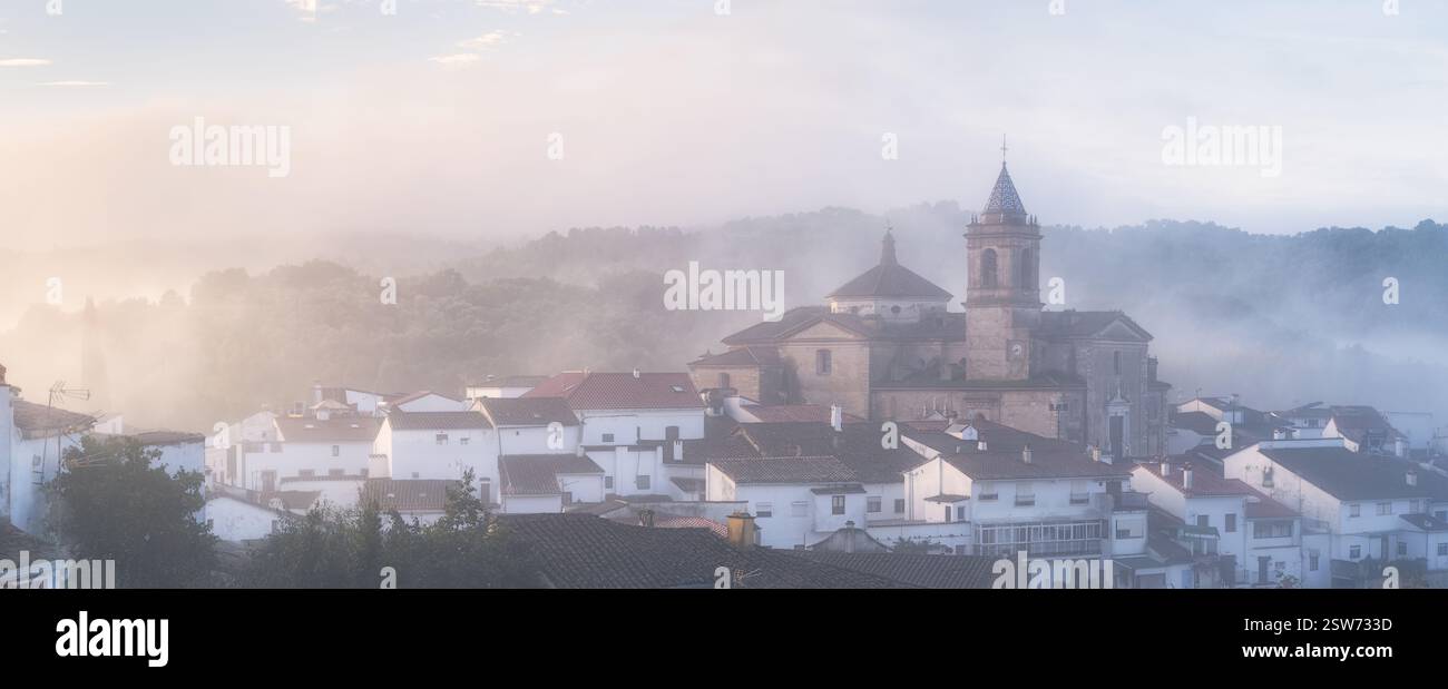 Misty Galaroza landscape. Church tower above village rooftops in serene ...
