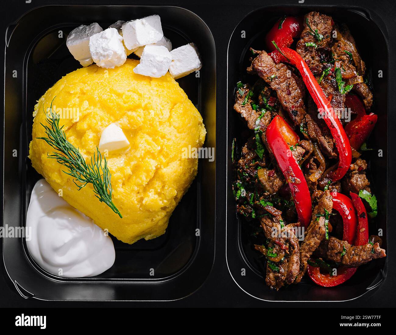 Takeout meal of beef stir-fry and polenta in black container Stock ...
