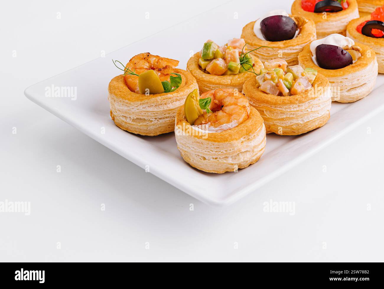 Gourmet assorted mini tartlets on white plate Stock Photo - Alamy