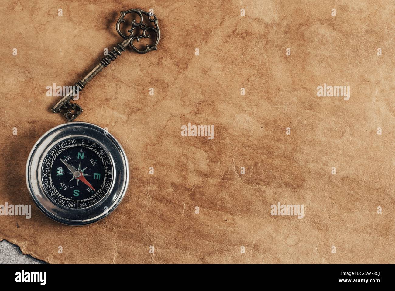Vintage key and compass on old paper background with copy space Stock ...