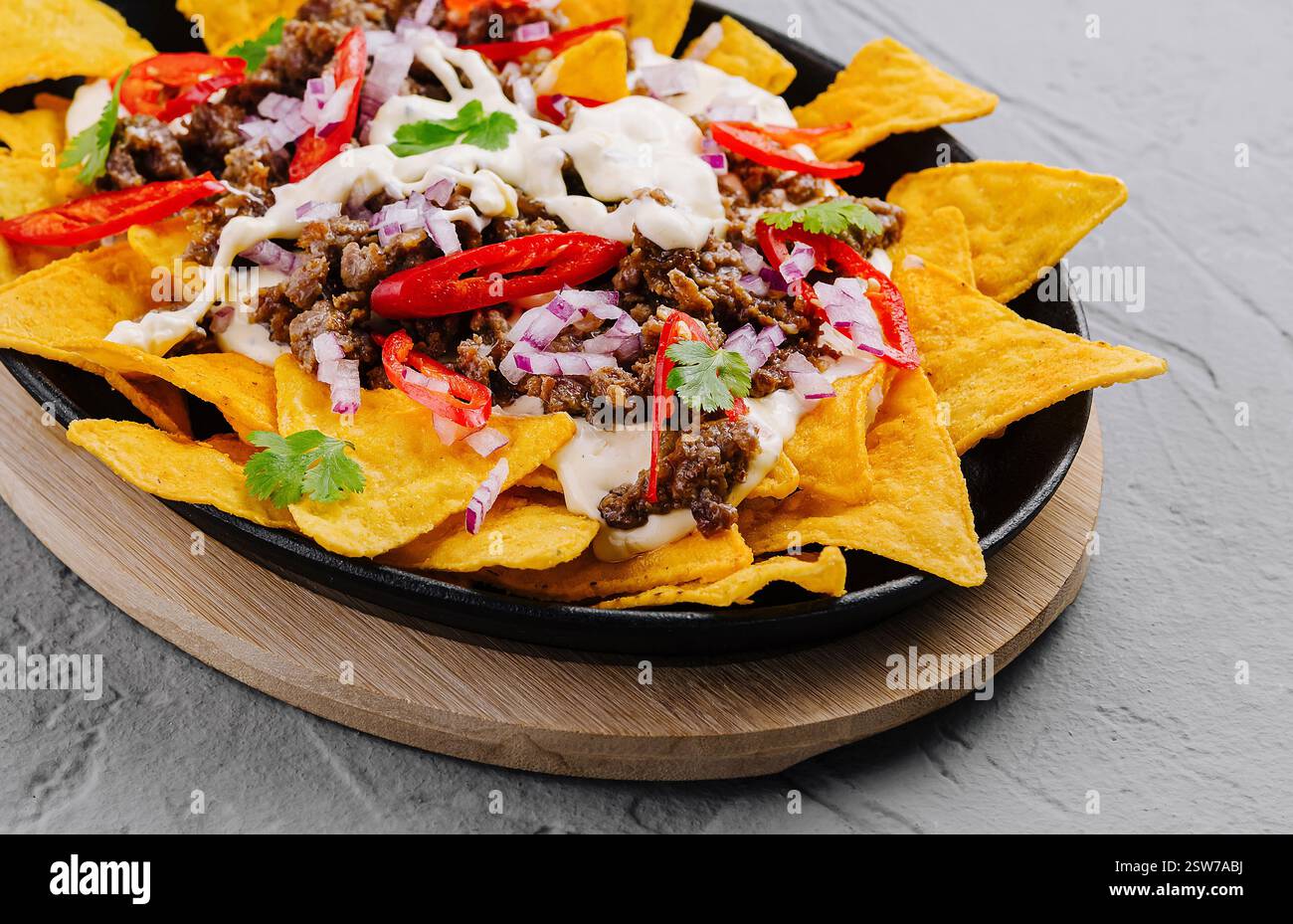 Loaded nachos on cast iron skillet Stock Photo - Alamy
