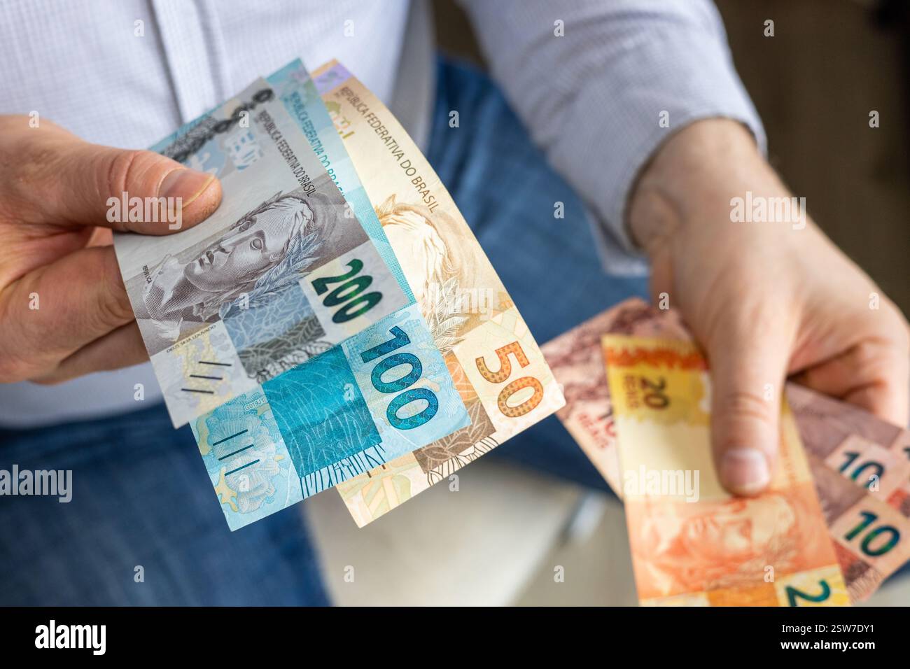 Brazil money. Businessman holding out his hand with Brazilian reais ...