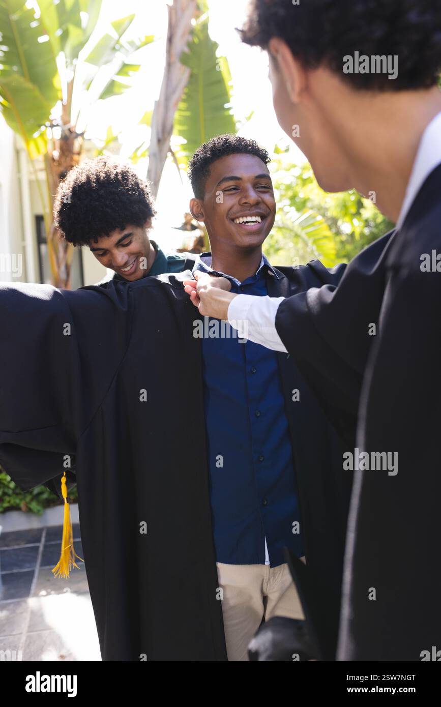 Diverse teen diverse friends in graduation gowns celebrating success ...