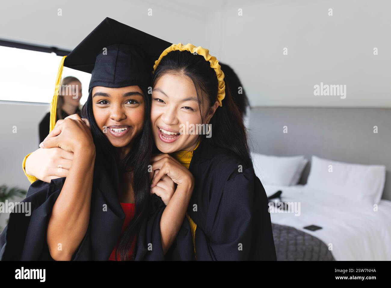 Graduating diverse teen diverse friends celebrating in caps and gowns ...