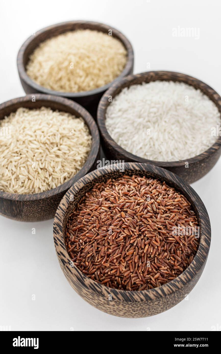different kinds of asian rice grains in bowls on white background in ...