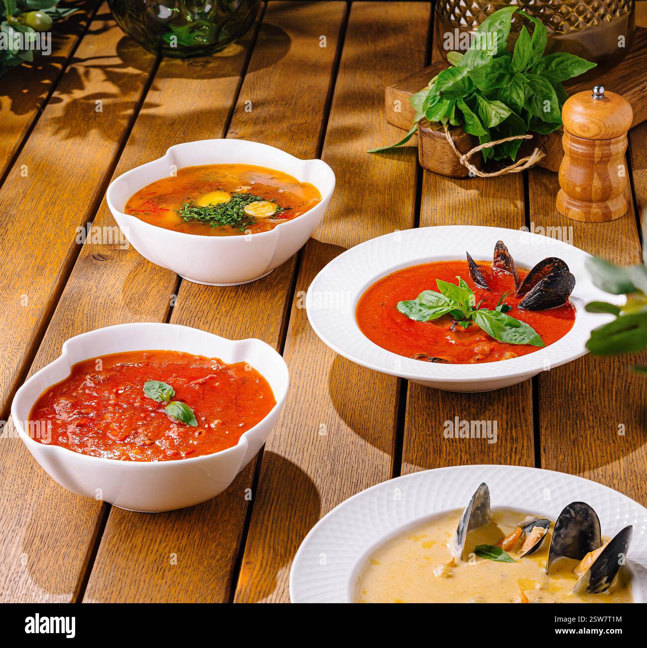 Elevated view of three delicious soup varieties served in white bowls ...
