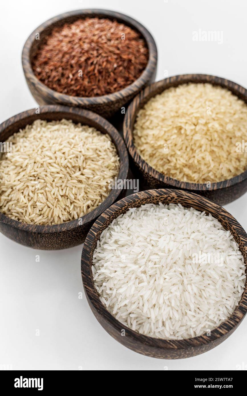 different kinds of asian rice grains in bowls on white background in ...