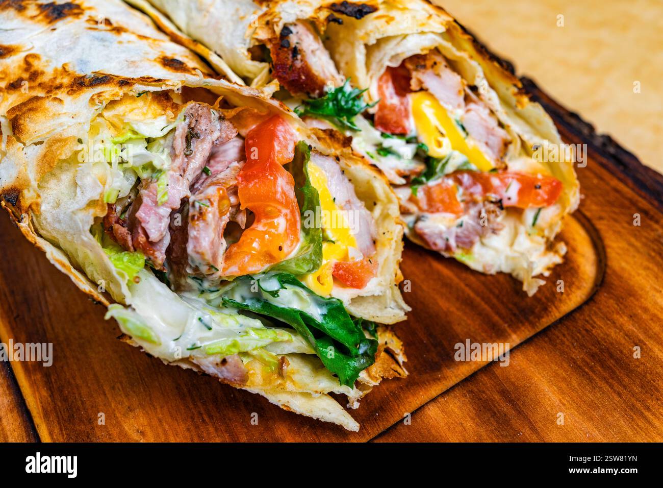 A mouthwatering burrito showcases grilled meat, vibrant vegetables, and ...