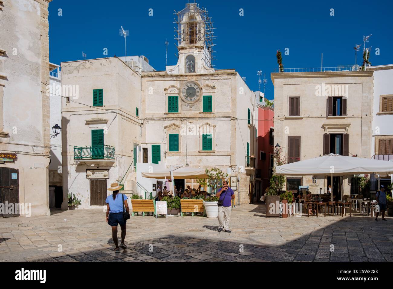 Polignano a Mare Italy 18 September 2024, Visitors stroll through a picturesque square in Puglia ...