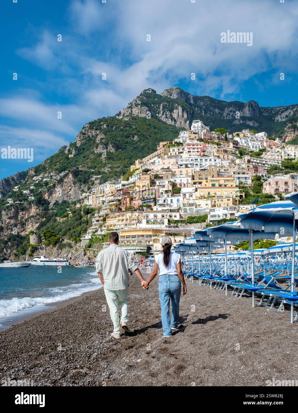 Strolling hand in hand along the sandy beach of Positano, Amalfi Coast ...