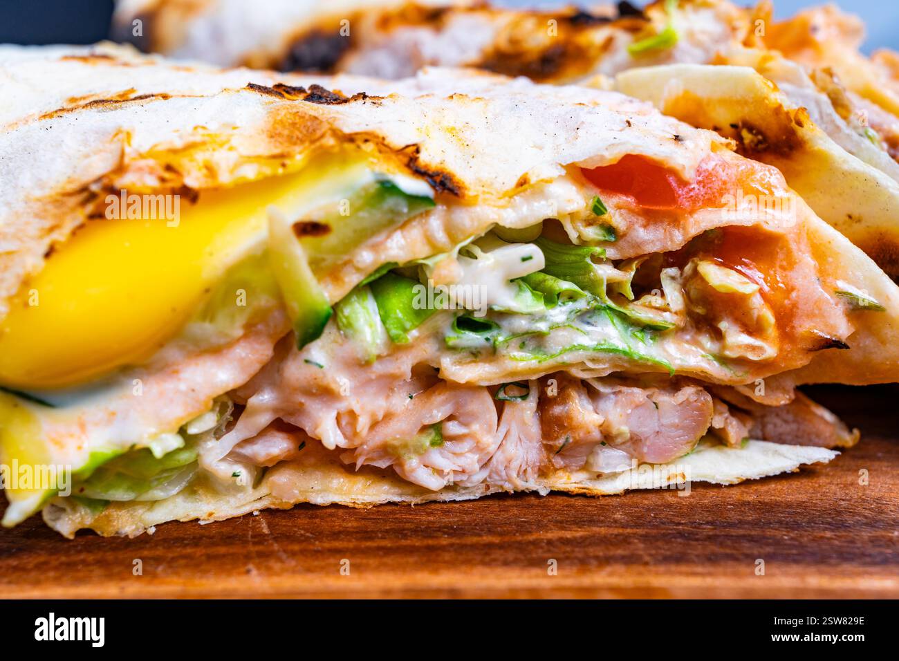 This dish showcases a tasty wrap filled with salmon, eggs, and fresh ...