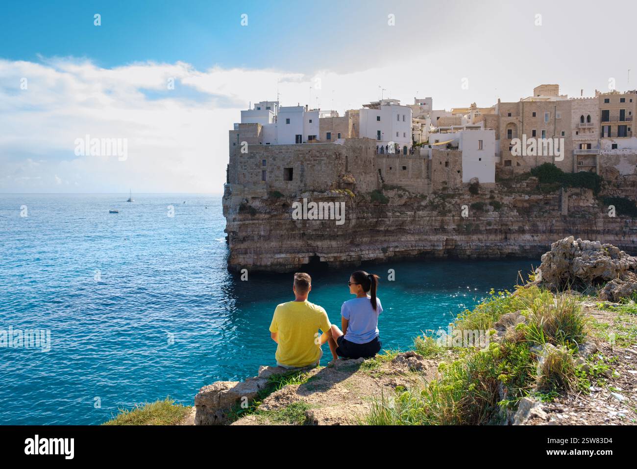 Polignano a Mare a Couple enjoying a serene moment by the turquoise ...