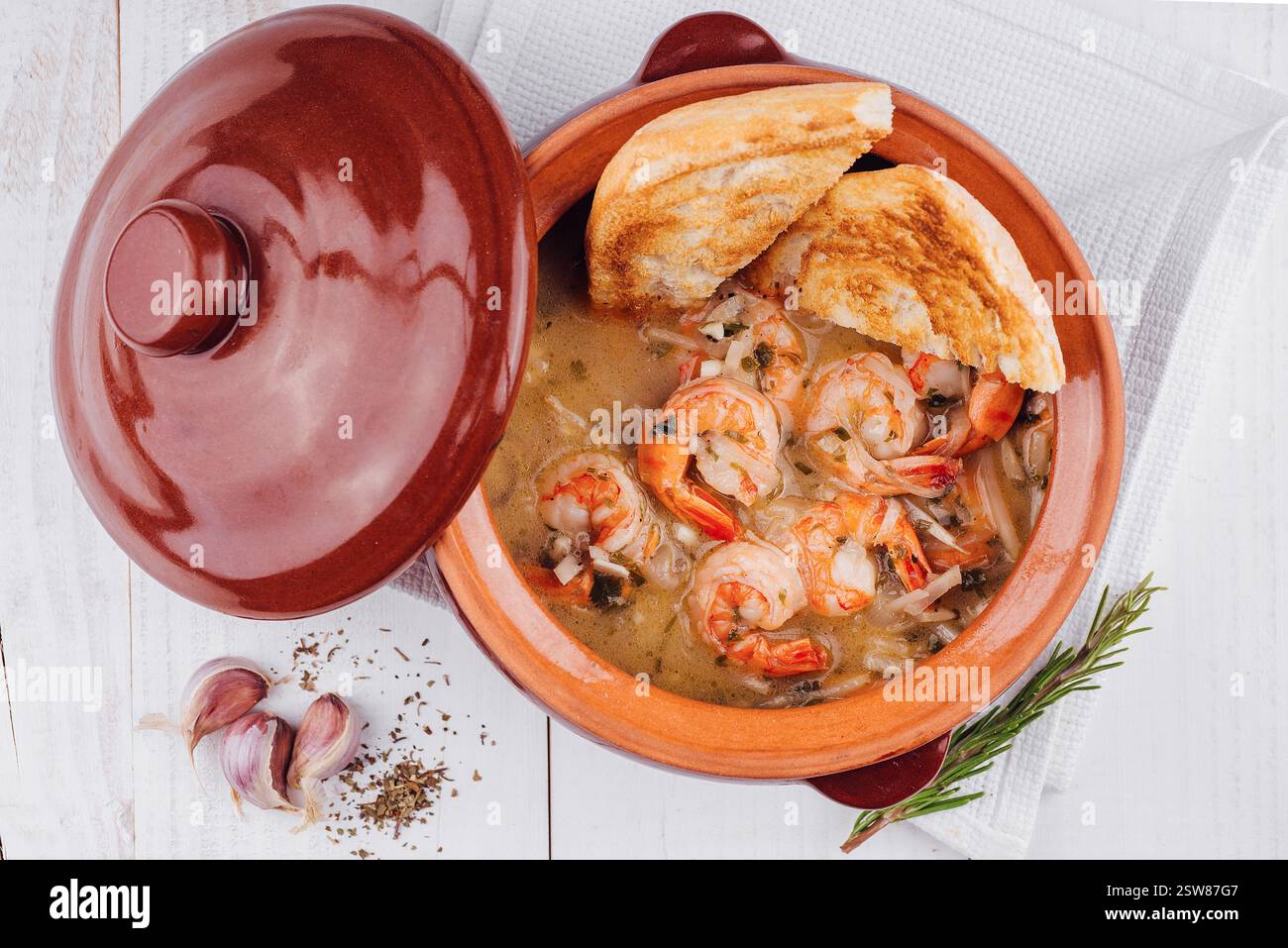 Creamy shrimp stew served in a terracotta bowl with toasted bread and ...