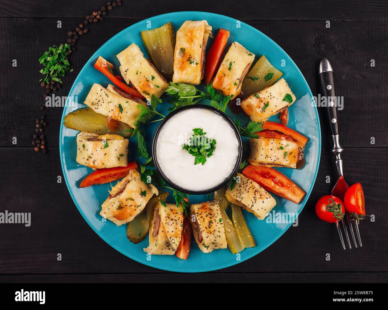 Turkish beyti kebab with vegetables and yogurt sauce on turquoise plate ...