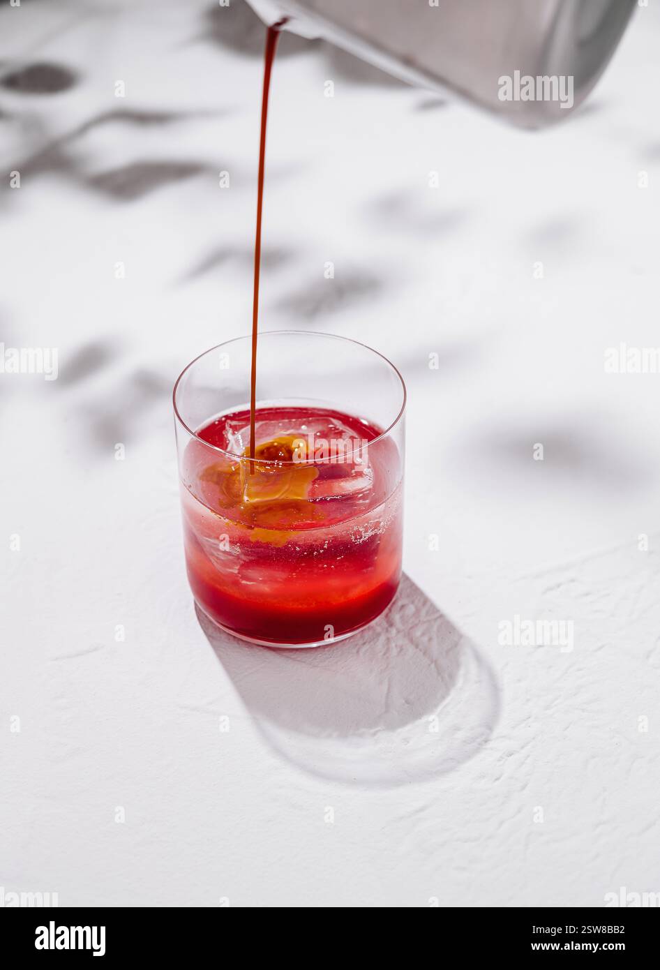 Bartender pouring syrup into cocktail with ice on white background ...