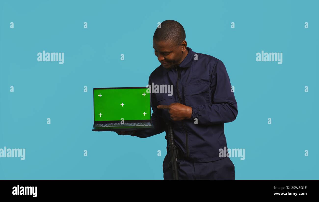 Portrait of happy security guard at work showcasing green screen laptop ...