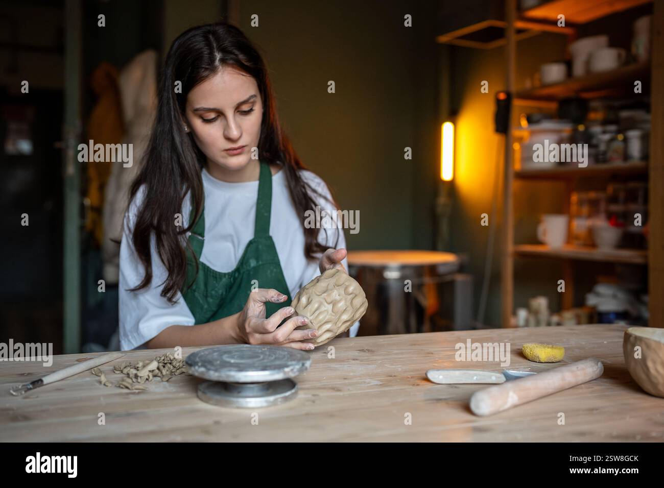 Molding craft ceramics: table in pottery studio with female artist ...