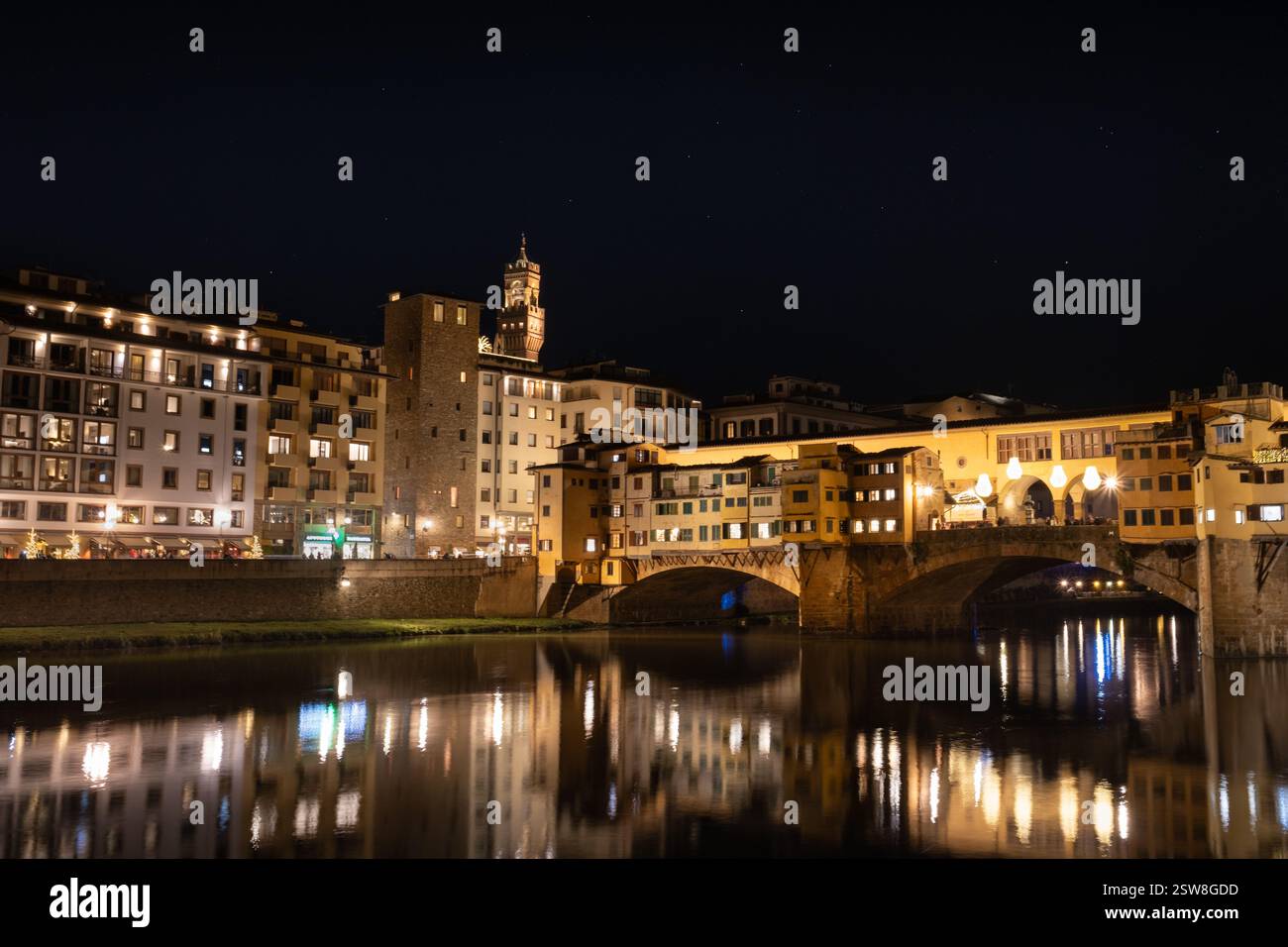 Night view of the Ponte Vecchio bridge with the Torre del Palacio Viejo ...