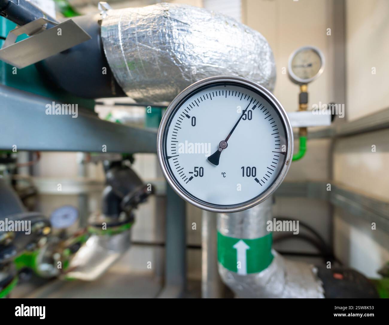 Industrial thermometer measuring pipeline temperature in a boiler room ...