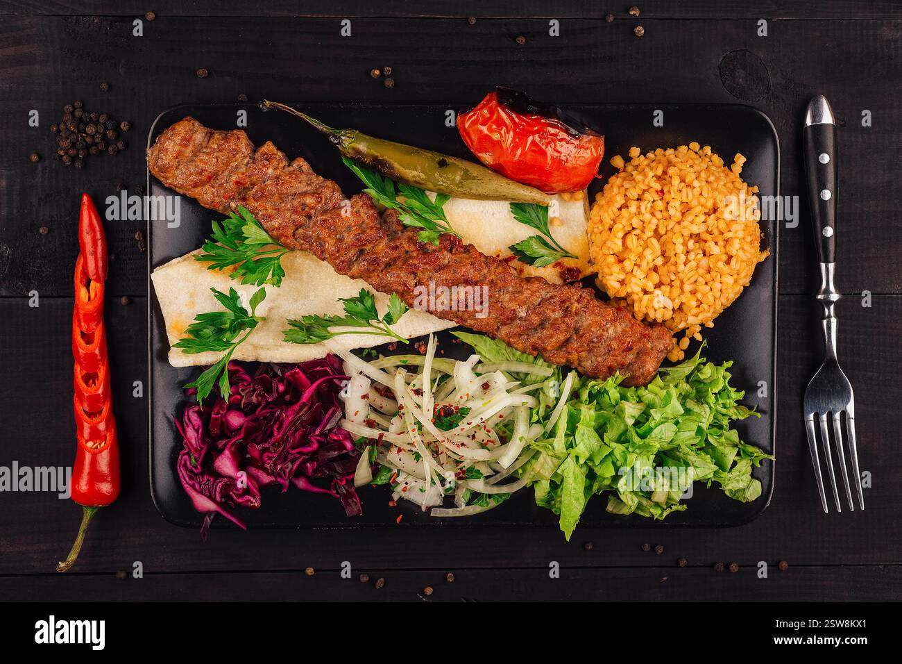 Traditional turkish adana kebab serving on a plate with grilled tomato ...