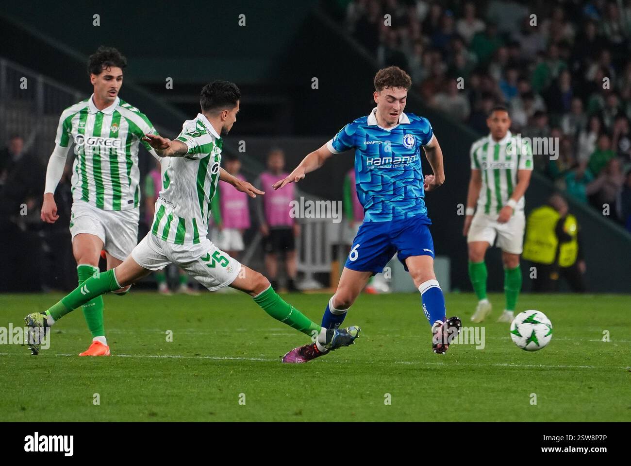 Betis' Marc Bartra and Gent's Mathias Delorge fight for the ball during ...