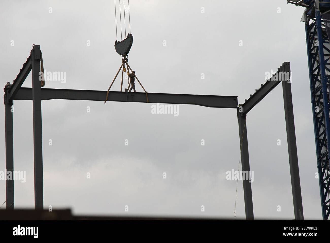 A construction worker on a steel beam in the heights while it is being ...