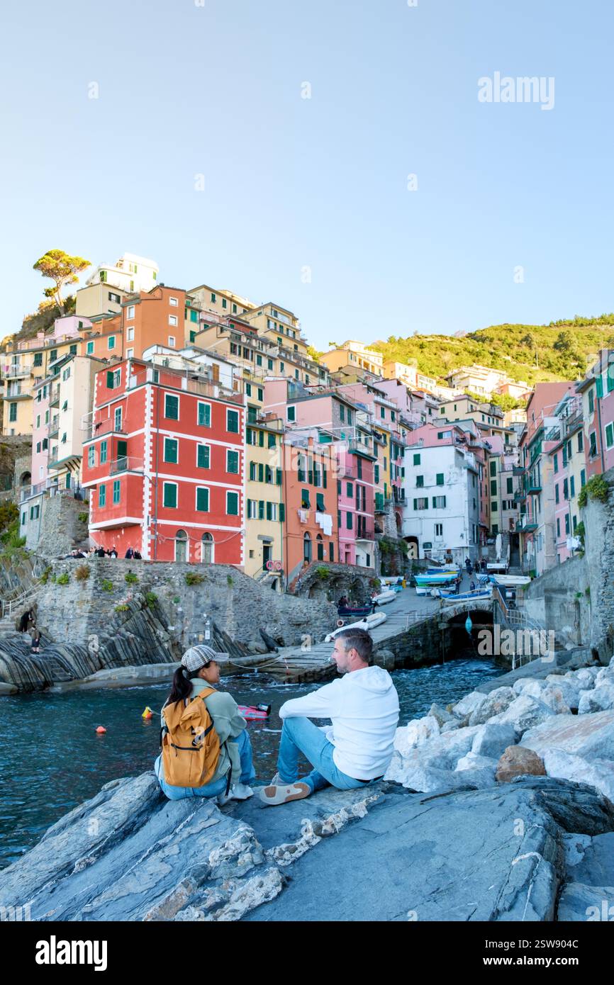 Sitting atop rugged rocks, two friends enjoy the stunning views of ...