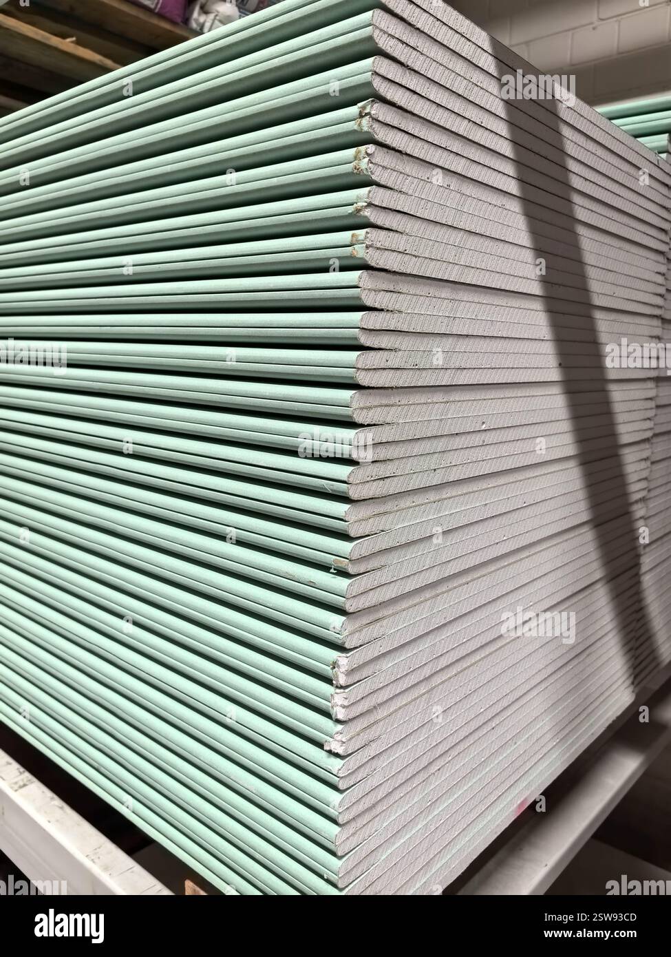 Neatly organized stacks of green building panels fill the warehouse ...
