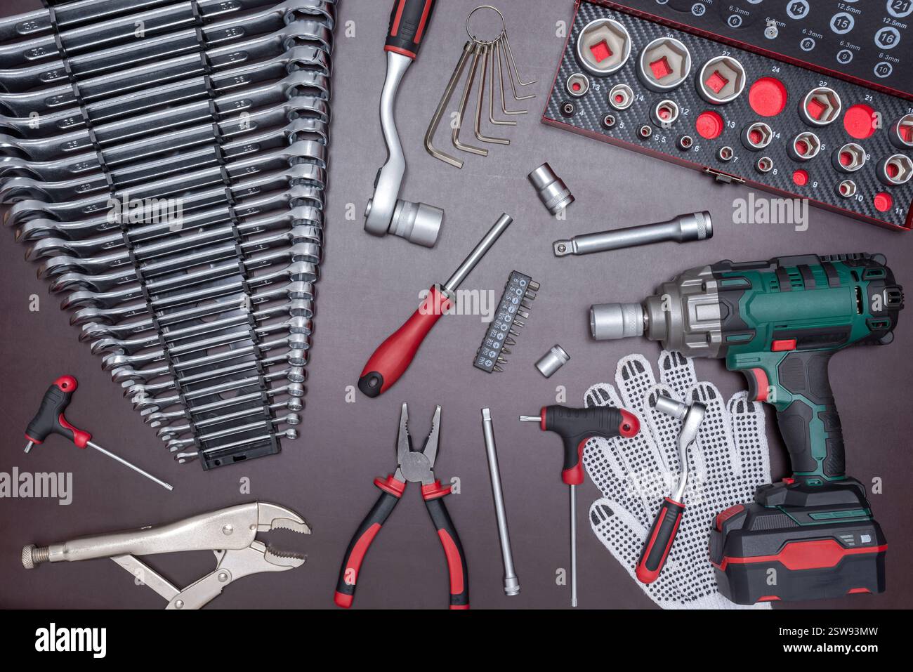 Various auto mechanic tools with cordless impact wrench on a work table ...