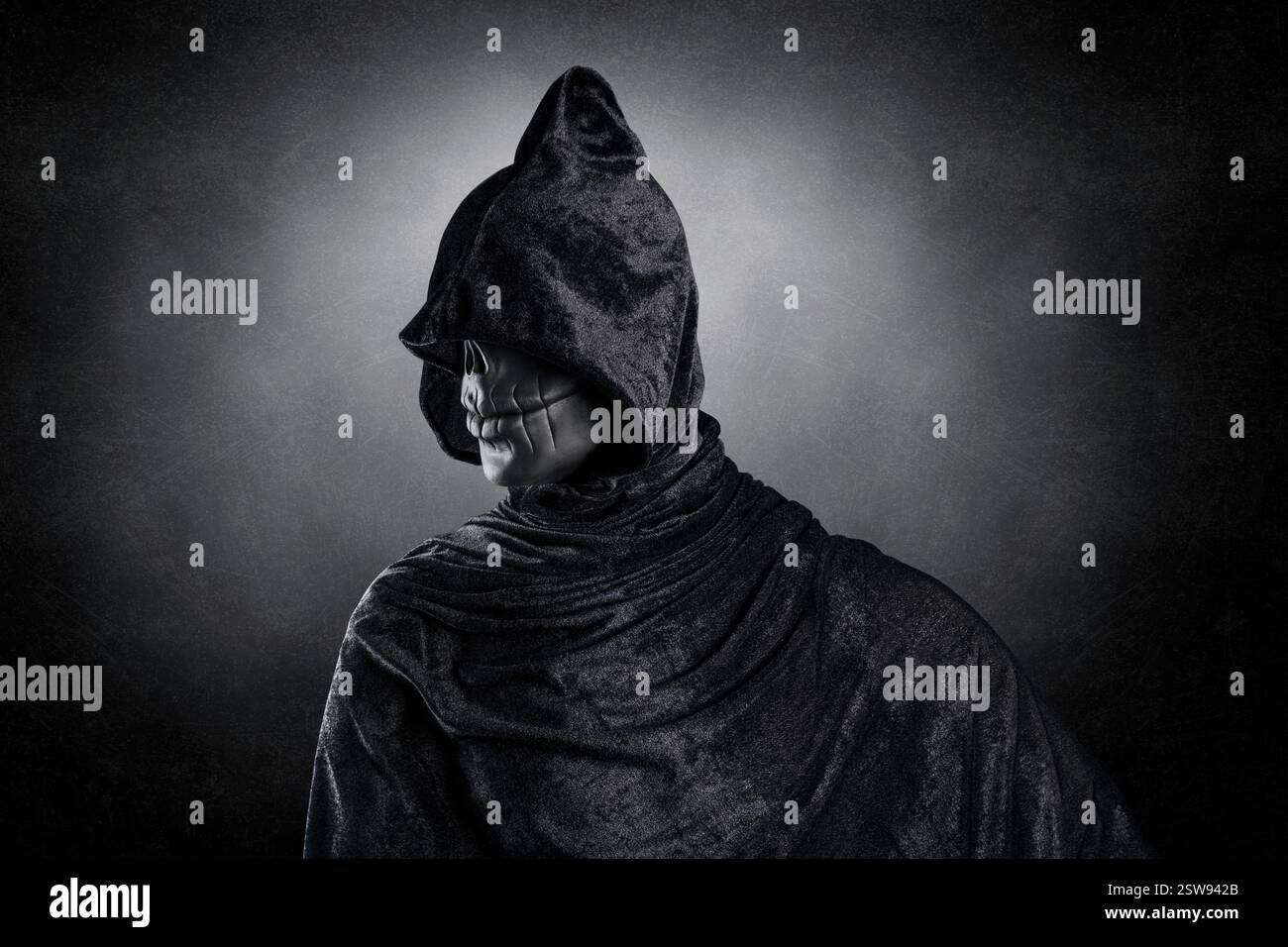 Scary figure with hooded cloak over dark misty background with clipping ...