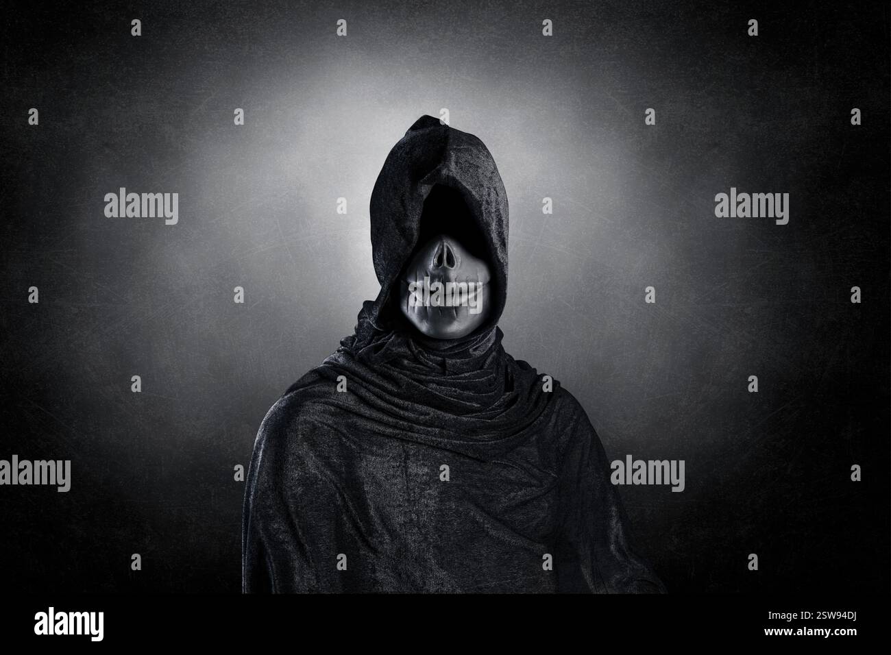 Scary figure with hooded cloak over dark misty background with clipping ...