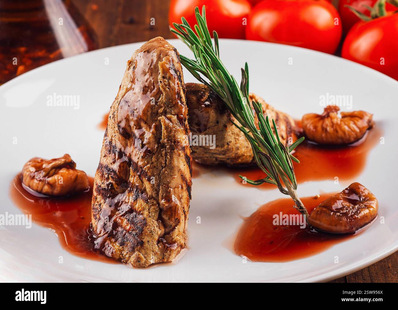 Grilled meat with figs and rosemary lying on a white plate Stock Photo ...