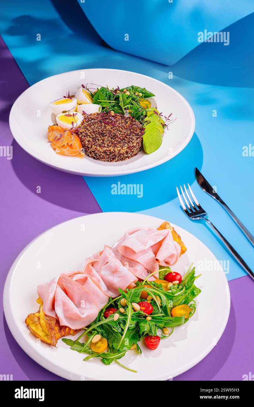 Two healthy dishes with quinoa, smoked salmon, omelette and ham served ...