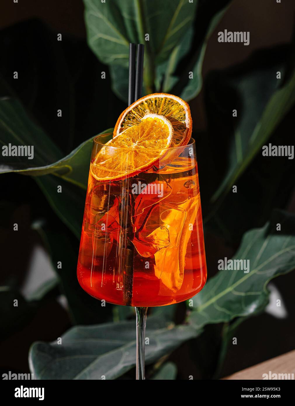 Refreshing aperol spritz cocktail standing on a table with tropical ...