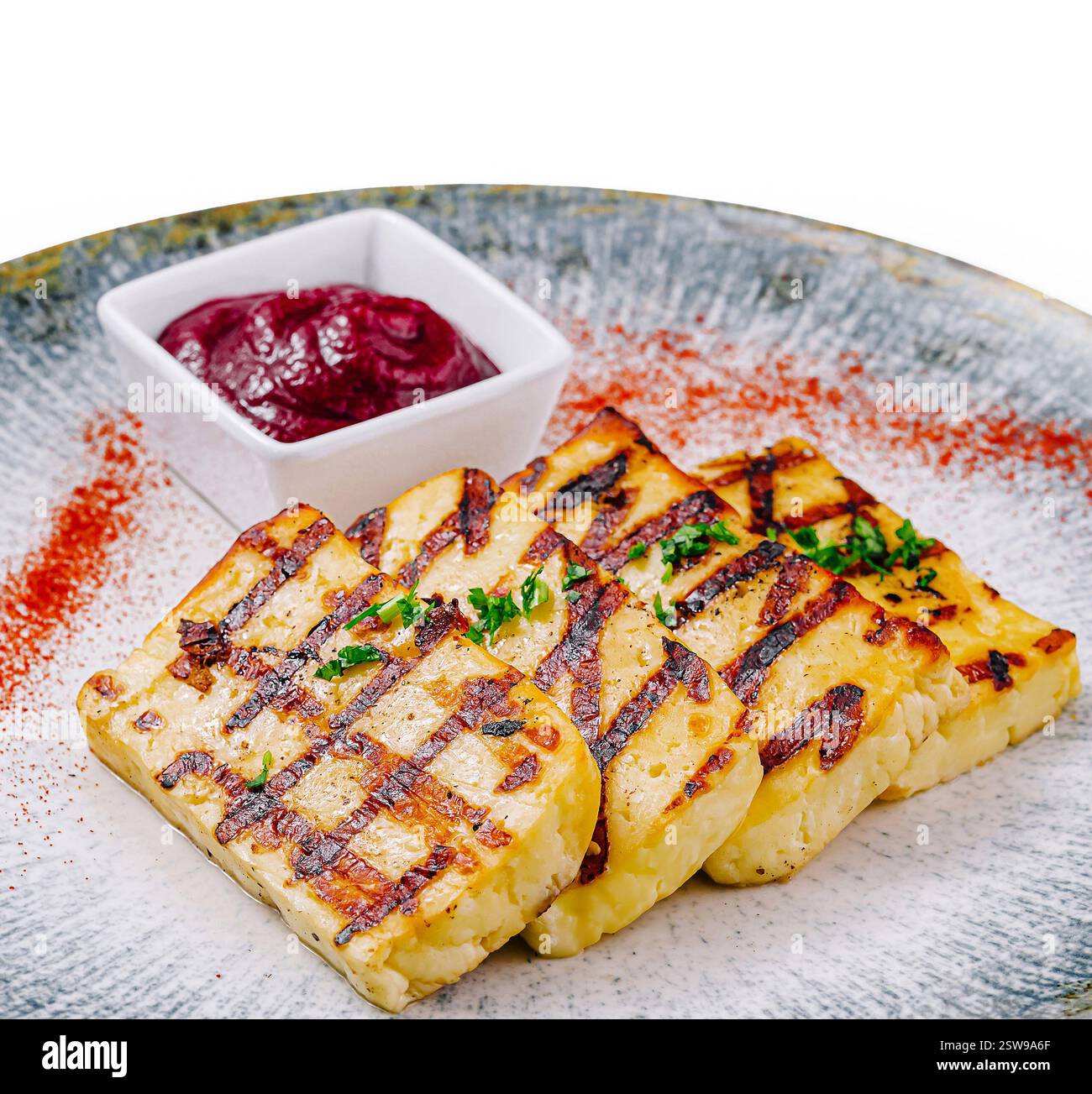 Grilled halloumi cheese with berry sauce on elegant restaurant plate ...