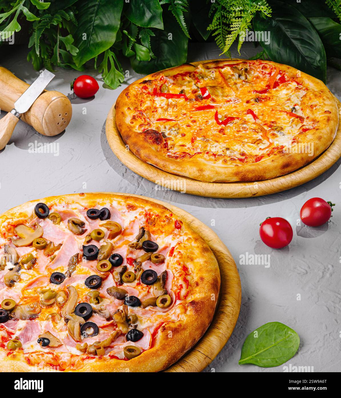 Two round pizzas with mushrooms and olives lying on wooden boards Stock ...