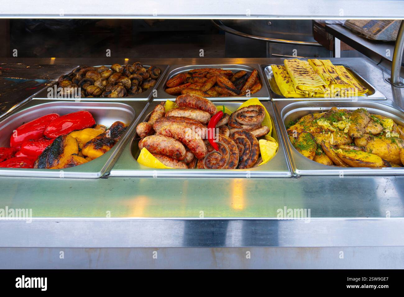 Street food. Large food display with vegetables and grilled meat ...