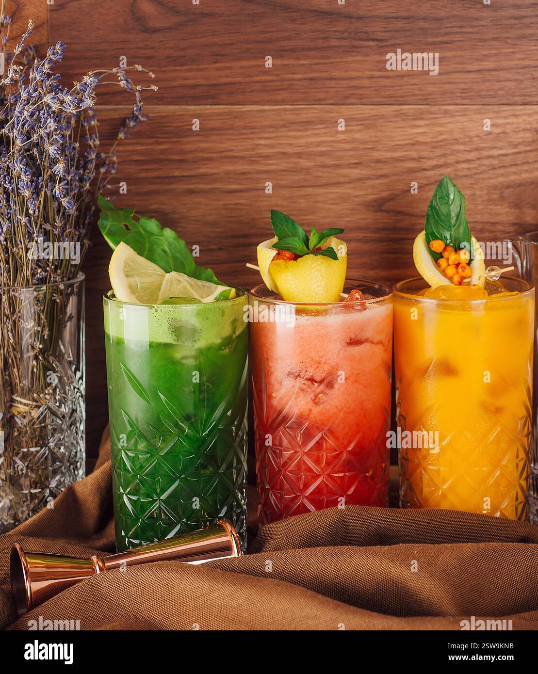 Three colorful cocktails with fruit and mint standing on bar counter Stock Photo - Alamy
