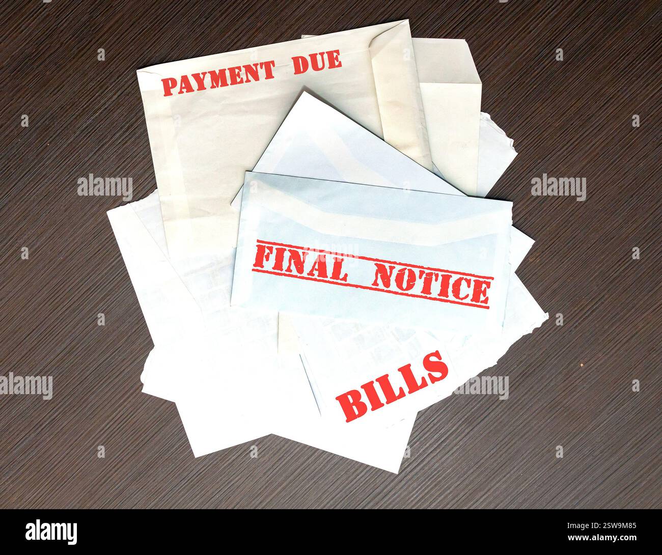 Large pile of envelopes with unpaid bills with warnings in red letters ...